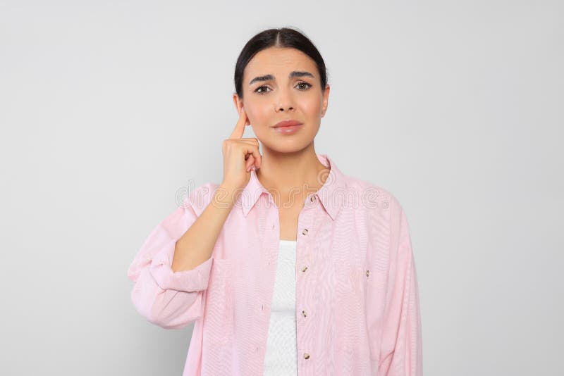 Young Woman Suffering from Ear Pain on Light Grey Background Stock ...