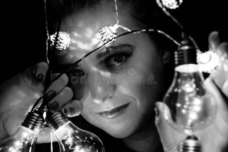 A Young Woman Surrounded by Lights Stock Photo - Image of idea, glance ...
