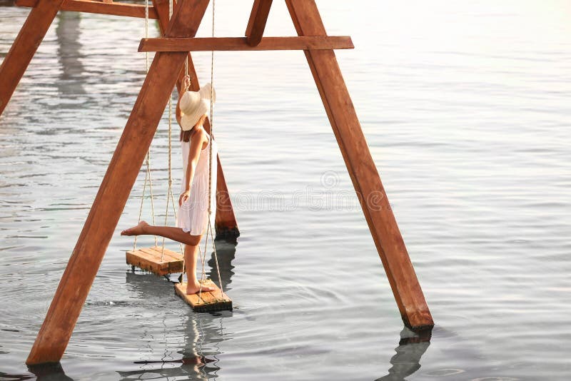 Young Woman on Swing Over Water on Sunny Day Stock Image - Image of ...
