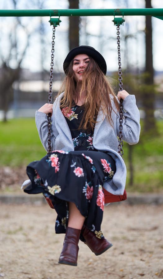 Young woman in a swing stock photo. Image of female - 215822920