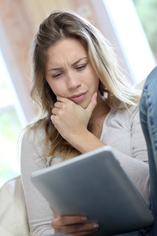 Young Woman on Tablet with Sad Look Stock Photo - Image of relaxing ...