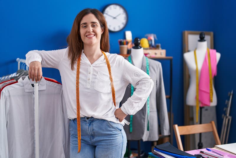 Young Woman Tailor Smiling Confident Leaning on Clothes Rack at Sewing ...