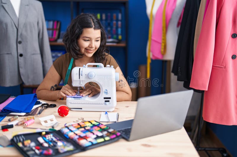 Young Woman Tailor Using Sewing Machine and Laptop at Sewing Studio ...