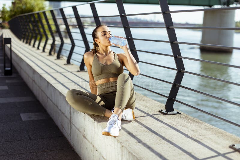Young Woman Taking a Break during Exercise on the River Promenade Stock ...