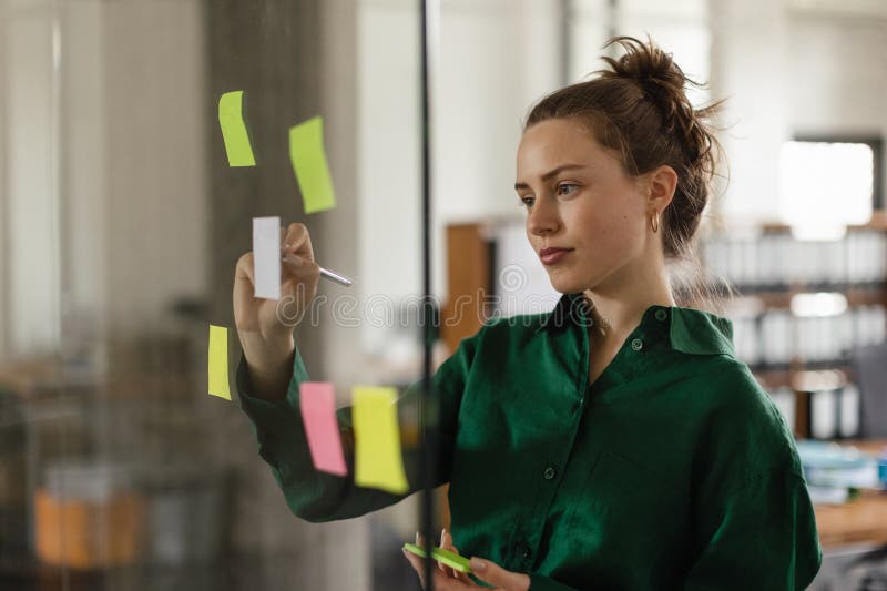 Young Woman Taking Notes in Her Office. Stock Image - Image of paper ...