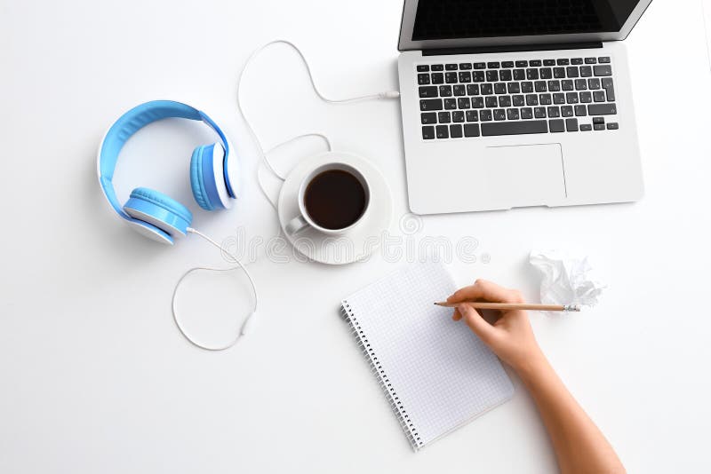Young Woman Taking Notes at Table with Laptop and Headphones Stock ...