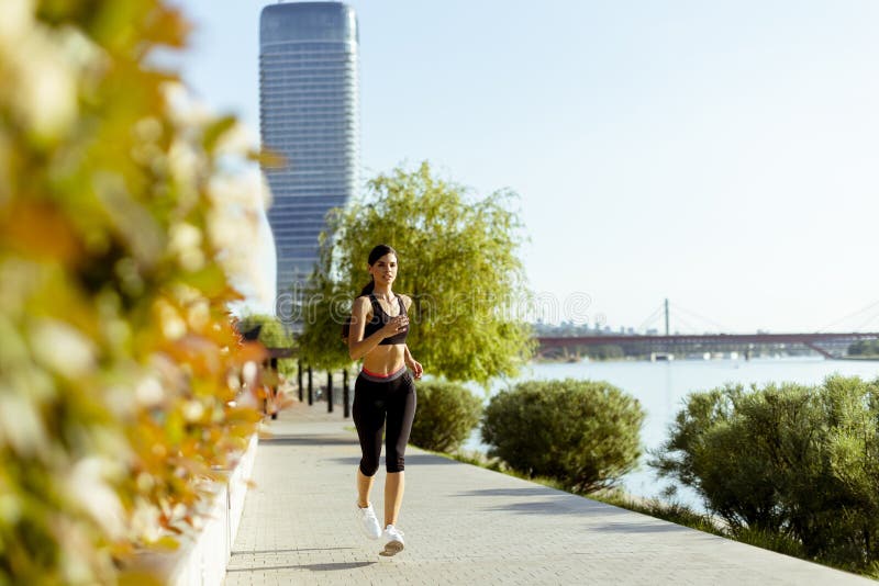 Young Woman Taking Running Exercise by the River Promenade Stock Photo ...