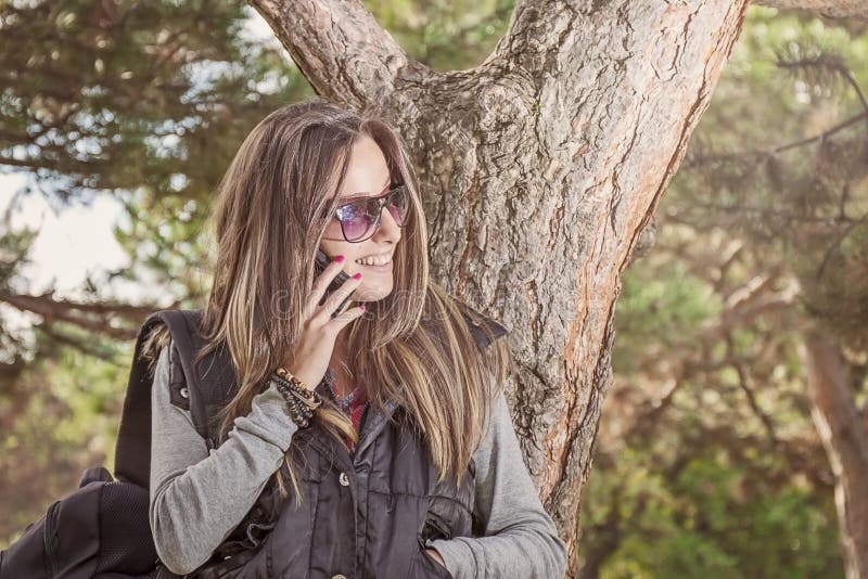 Young Woman Talking on the Phone Outside Under a Tree Stock Image ...