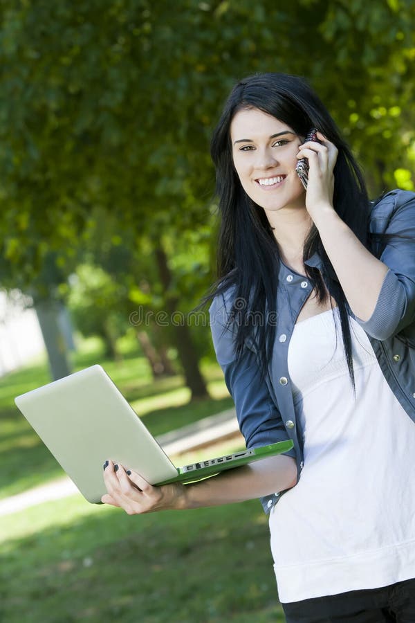 A Young Woman Talks on Phone with Computer Stock Photo - Image of lady ...