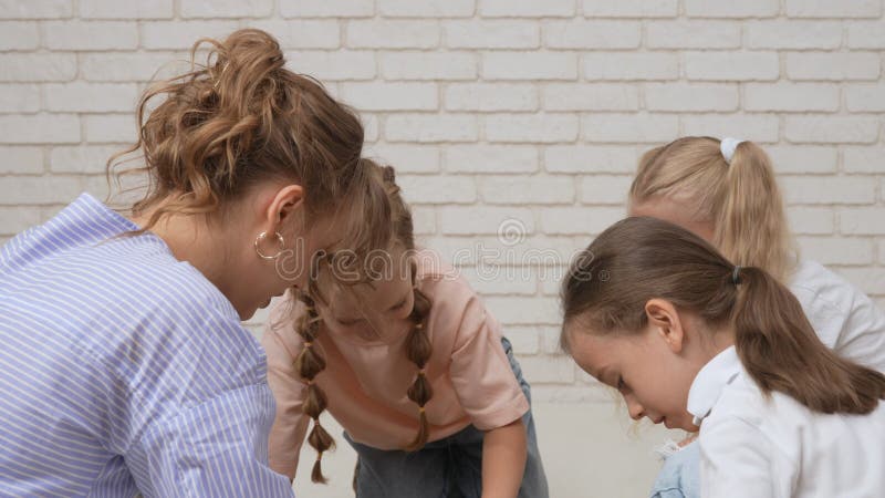 Young Woman Teacher and Group of Children Sitting on the Floor and ...