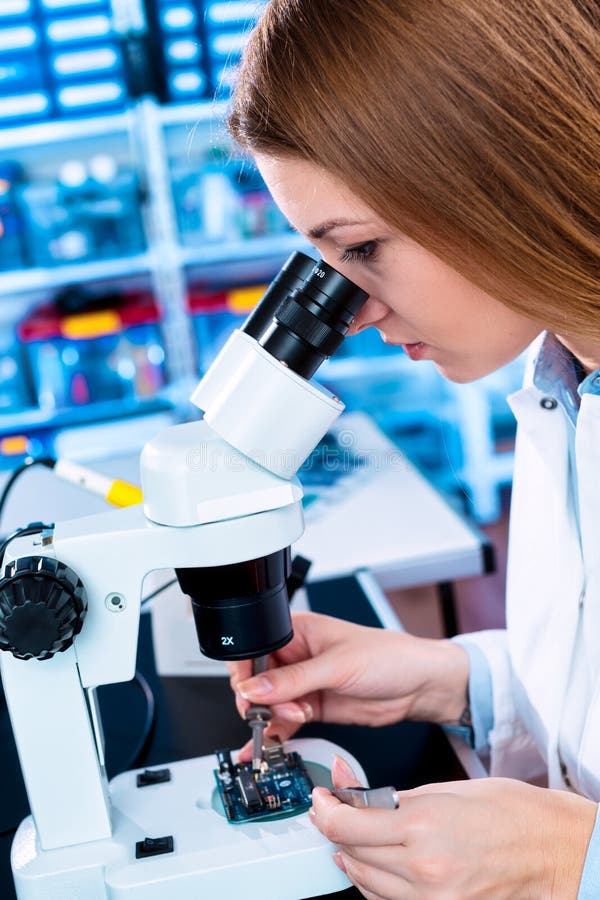 A Young Woman is Testing an Electronic Module for the Production of ...