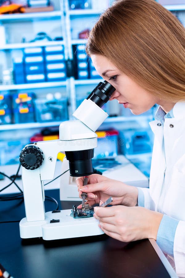 A Young Woman is Testing an Electronic Module for the Production of ...