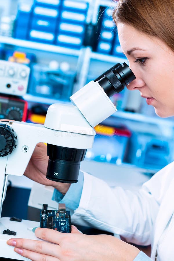 A Young Woman is Testing an Electronic Module for the Production of ...