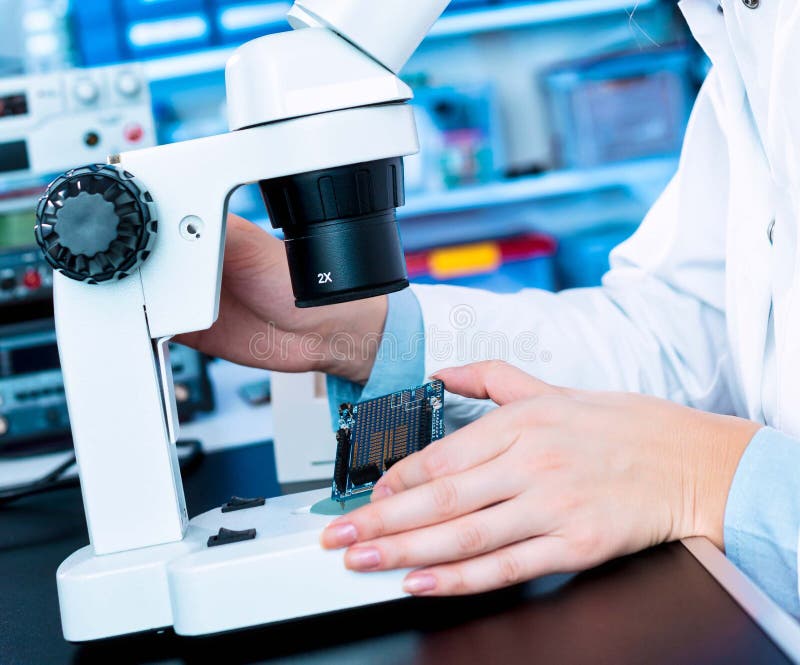A Young Woman is Testing an Electronic Module for the Production of ...