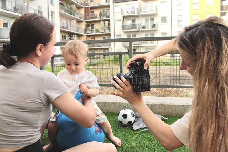 A Young Woman Tests the Camera by Photographing a Child Stock Image ...