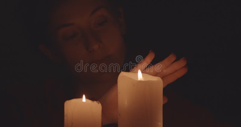 Young Woman Touching Candle`s Flame in Darkness Stock Video - Video of ...