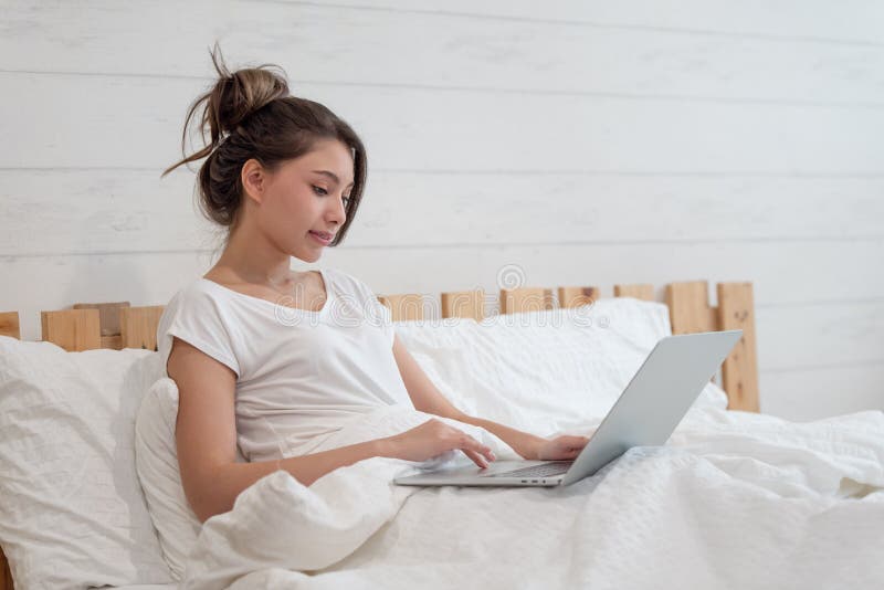 Young Woman Using Computer In Bedroom Stock Photo - Image of beautiful ...