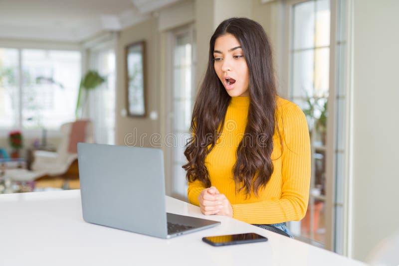 Young Woman Using Computer Laptop Afraid and Shocked with Surprise ...
