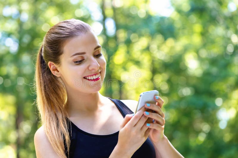Young Woman Using Her Phone Stock Photo - Image of beautiful, outdoor ...