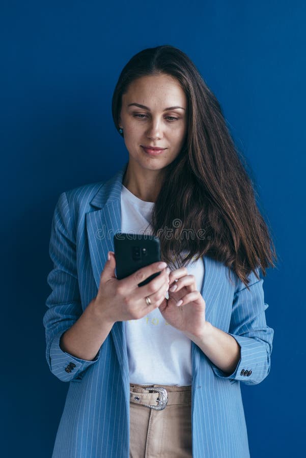 Young Woman Using Her Smart Phone Standing Against the Wall Stock Image ...