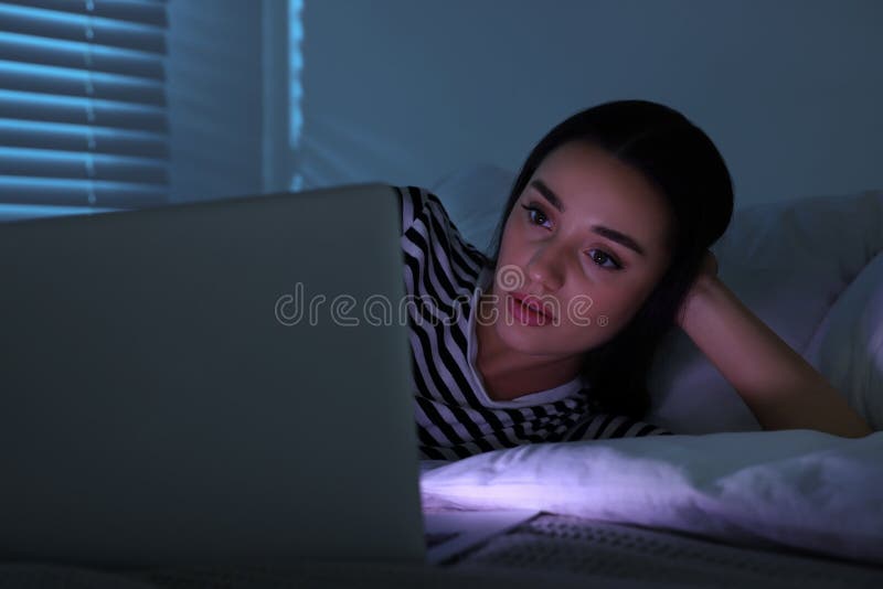 Young Woman Using Laptop on Bed at Night. Internet Addiction Stock ...