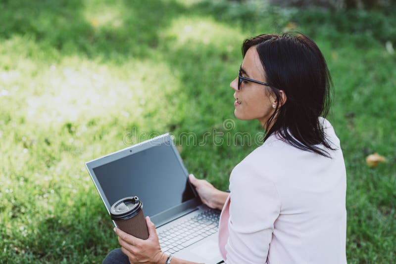 Young Woman Using Laptop with Blank Screen in Public Park while Working ...