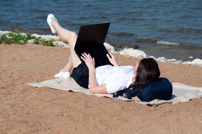Young Woman Using Laptop Computer on a Beach. Freelance Work Concept ...