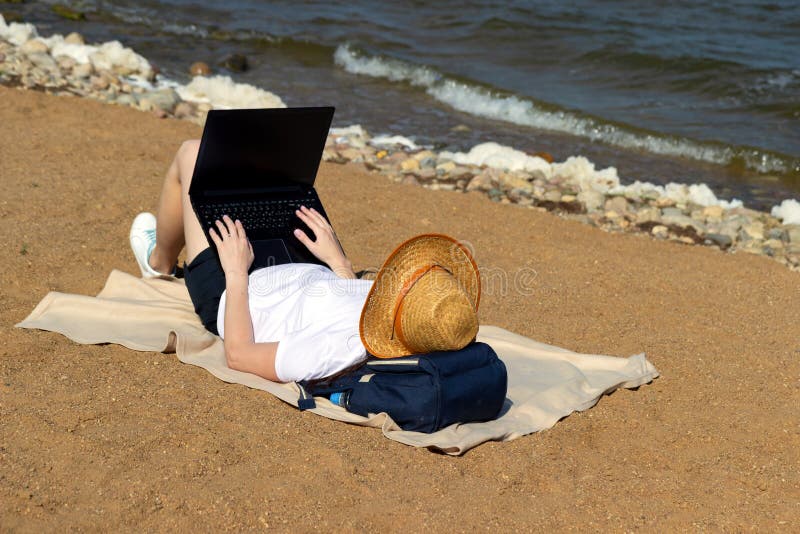 Young Woman Using Laptop Computer on a Beach. Freelance Work Concept ...