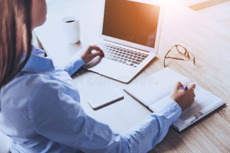 Young Woman Using Laptop and Writing Notes at Table. Stock Image ...
