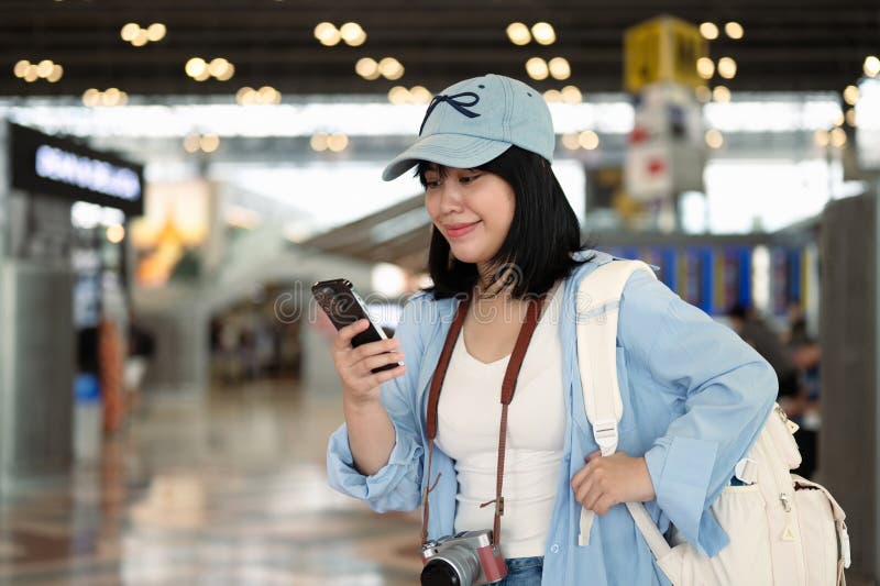 Young Woman Using Mobile Phone in an Airport Terminal for Checking ...