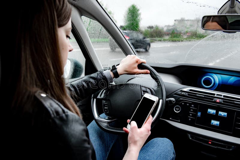 Young Woman Using Mobile Phone while Driving Car on Bad Weather ...