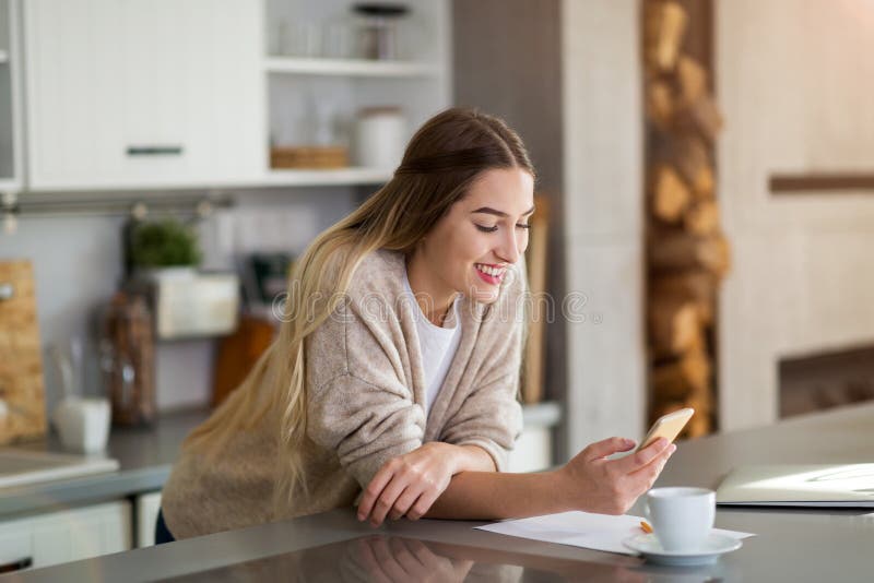 Young Woman Using Mobile Phone in the Kitchen Stock Image - Image of ...