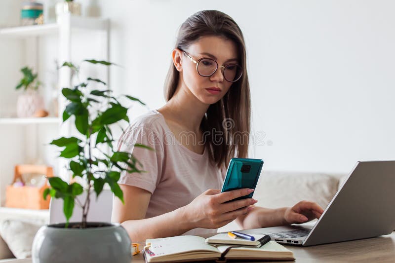 Young Woman Using Mobile Phone and Laptop To Work Home, Multiple ...