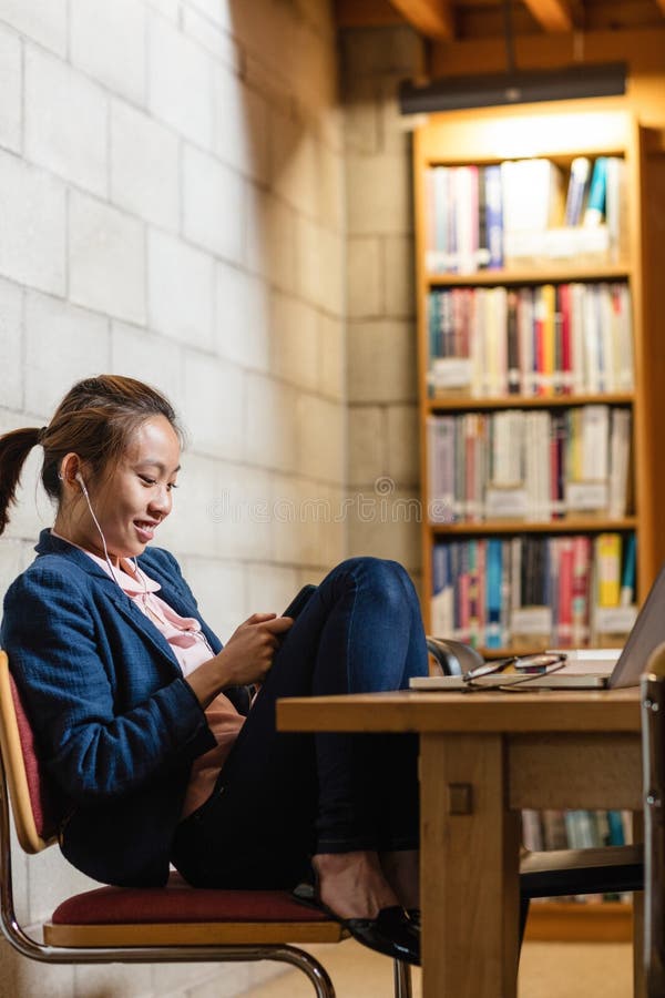 Young Woman Using Mobile Phone in Library Stock Photo - Image of ...