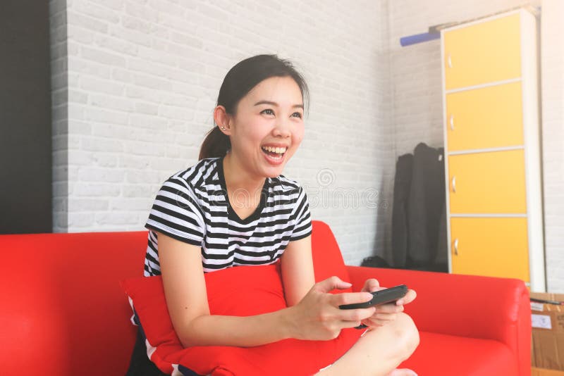 Young Woman Using Mobile Phone while Sitting on Red Sofa Stock Image ...