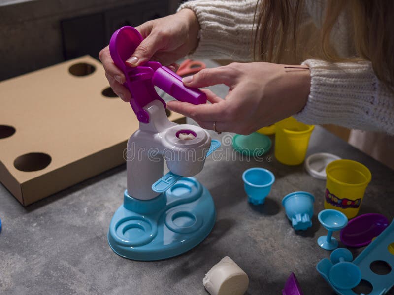 Young Woman Using Modeling Clay Extruder Toy Set, Loading Clay into ...