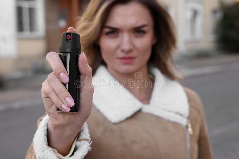 Young Woman Using Pepper Spray Outdoors, Focus on Hand Stock Photo ...