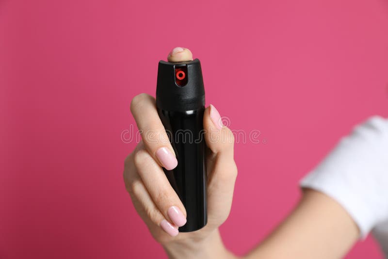 Young Woman Using Pepper Spray on Pink Background, Closeup Stock Image ...