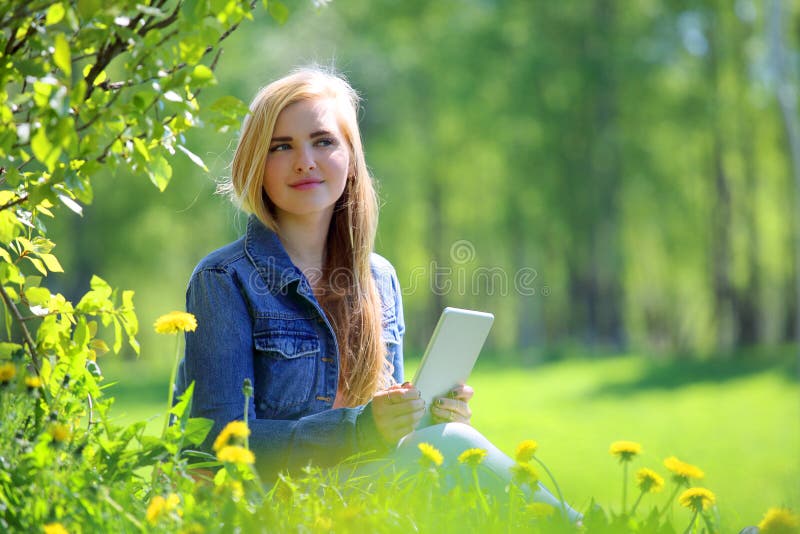 Young Woman Using Tablet in Park Stock Image - Image of dandelion ...