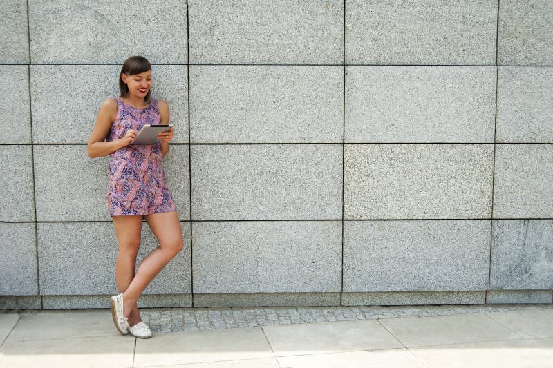 Young Woman Using Tablet Standing Against the Wall in the City S Stock ...