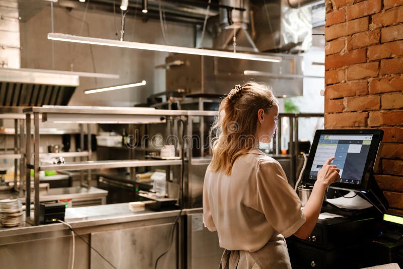 Young Woman Waitress Using Computer Terminal while Working in ...