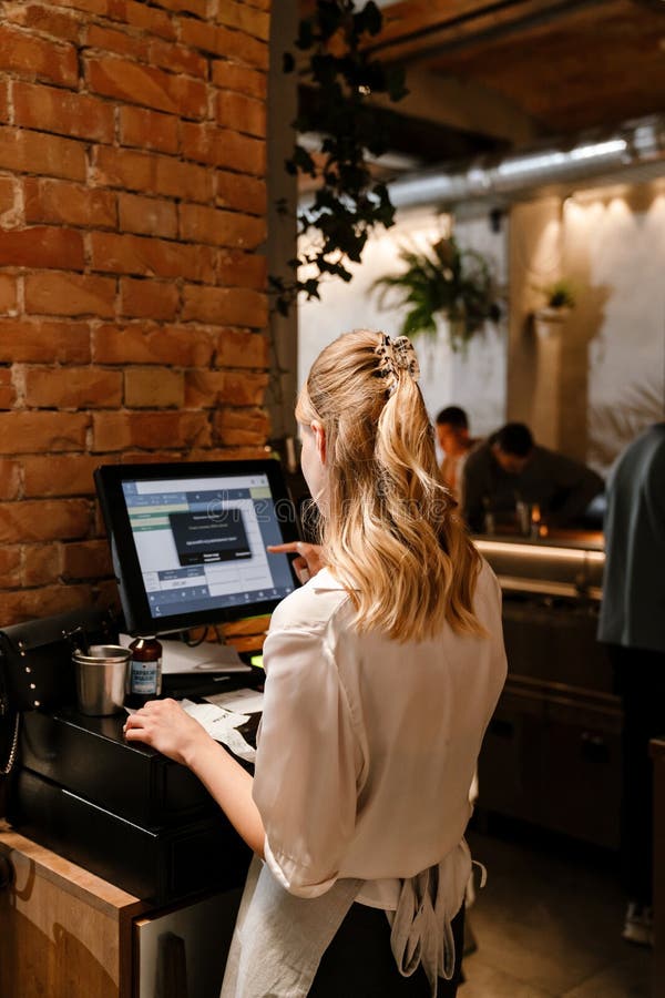 Young Woman Waitress Using Computer Terminal while Working in ...