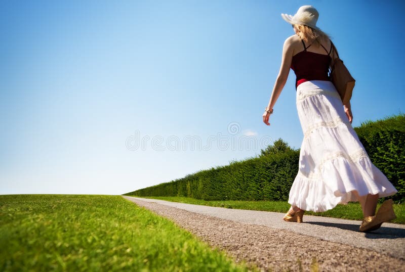 Young Woman Walking Fast on a Road Stock Image - Image of dress, angle ...