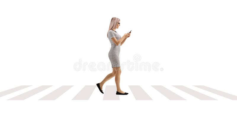 Young Woman Walking and Using a Smartphone at a Pedestrian Crossing ...