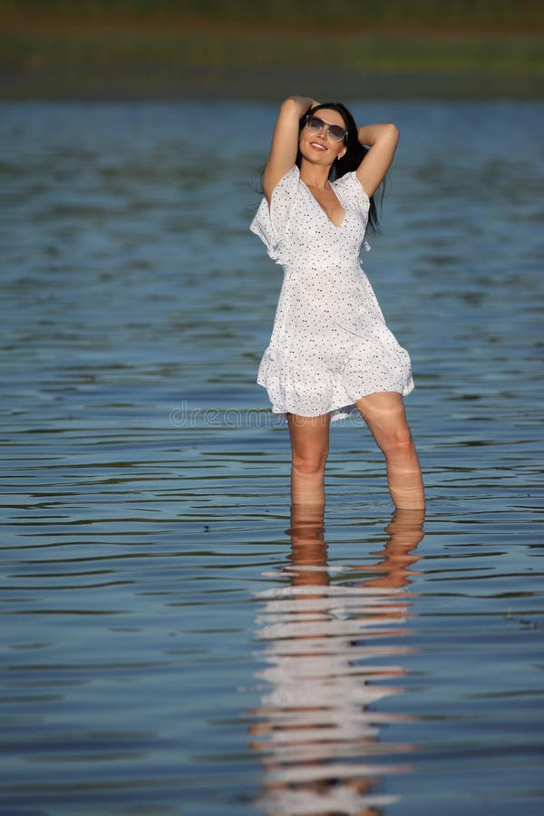 Young Woman in the Water in a Dress Stock Photo - Image of foam, tide ...