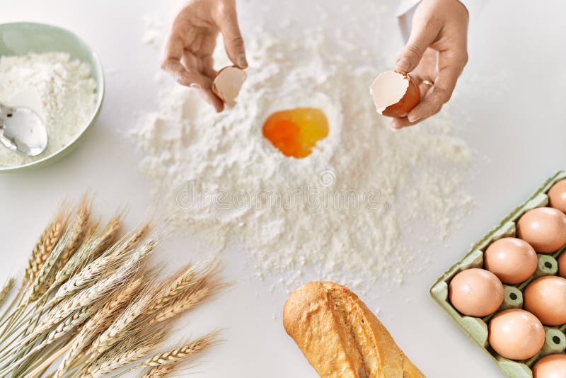 Young Woman Wearing Cook Uniform Cracking Egg on Flour at Kitchen Stock ...