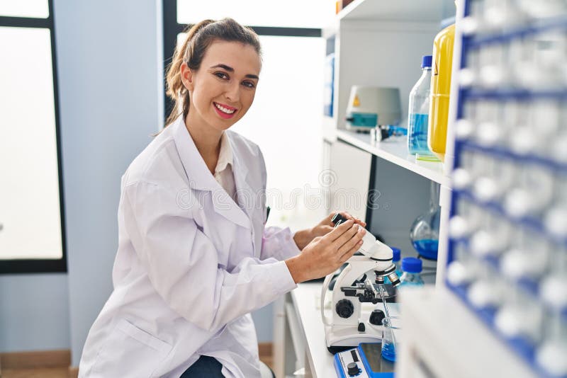 Young Woman Wearing Scientist Uniform Using Microscope at Laboratory ...