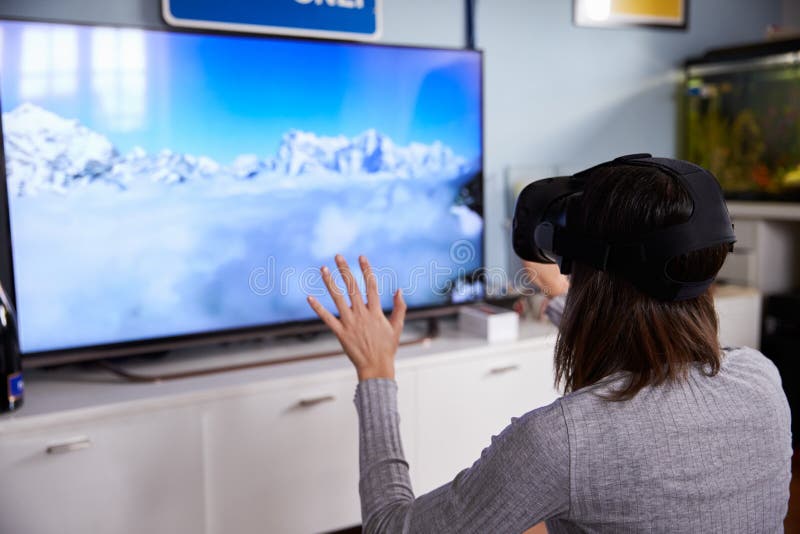 Woman Watching Television Wearing Virtual Reality Headset Stock Photo ...