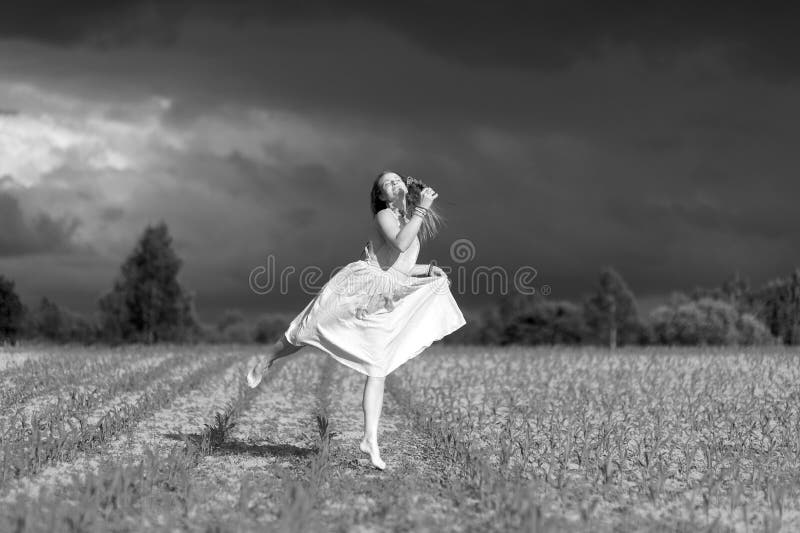 Woman Dancing in a Field Under a Dramatic Sky Stock Photo - Image of ...