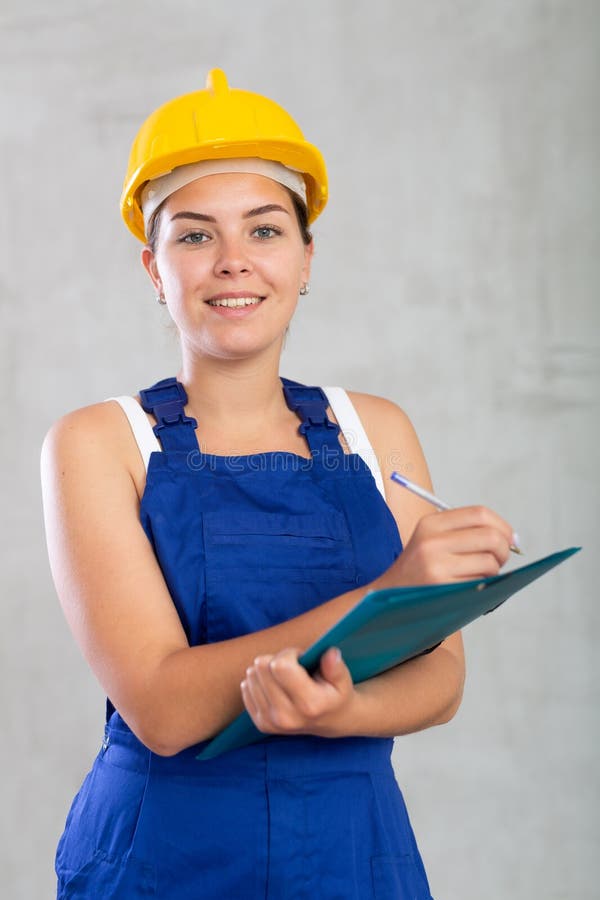 Young Woman in Work Overalls Making Notes Stock Photo - Image of ...
